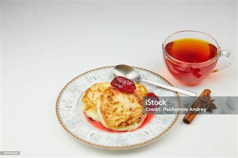 잼 홍차와 함께 접시에 치즈입니다 코 티 지 치즈 팬케이크 또는 흰색 테이블에 차 한 잔과 딸기 잼 팬케이크 전통적인 러시아 아침 식사입니다 세로 보기입니다 건조한에 대한