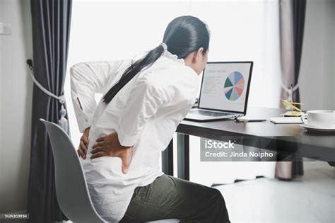 젊은 아시아 여성은 직장에 앉아 목에 긴장 통증이 있습니다 개념 사무실 증후군 직업병으로 인한 요통 노트북 컴퓨터를 사용하여 근육통을 앓고있는 여성 허리 통증 아시아인에