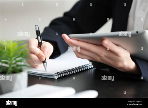 Female Babe With Tablet Computer Writing In Notebook At Table Closeup Studying Process