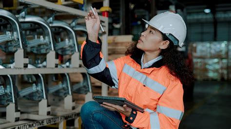 무역 회사의 창고에서 기계 부품을 세고 디지털 태블릿에 숫자를 기록하는 젊은 아시아 여성 노동자 예비 부품에 대한 스톡 사진 및