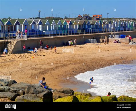 Southwold Seafront In Summer With Waves Crashing On To The Beach And