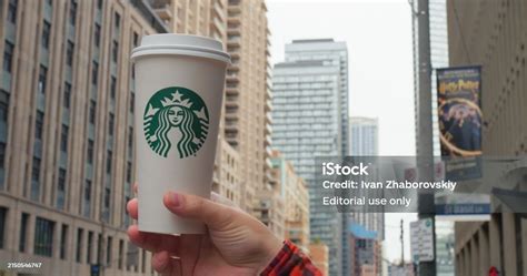 캐나다 토론토 2023년 5월 6일 스타벅스 컵을 손에 들고 상징적인 도시 배경 스타벅스가 친숙한 편안함을 제공하는 동안 도시의