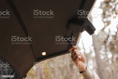 알아볼 수 없는 남자가 트렁크 핸들을 잡고 공원 야외에서 자동차 트렁크 도어를 닫습니다 프레스티지 현대 차량의 내부 세부 사항