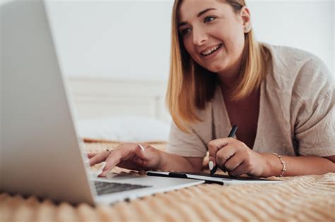 쾌활한 백인 여성이 호텔 방에서 침대에 누워 디지털 태블릿과 노트북으로 작업하고 직장에서 프리랜서 펜과 손에 집중 그래픽 타블렛에 대한 스톡 사진 및 기타 이미지 Istock