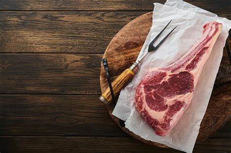 신선한 토마 호크 생 스테이크 오래된 나무 배경에 허브와 소금을 곁들인 건조 숙성 생 토마호크 쇠고기 스테이크 그릴 준비 평면도 및 복사 공간 0명에 대한 스톡 사진 및