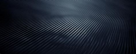 A Dark Black Textured Surface With A Subtle Brushed Appearance Resembling Carbon Fiber The