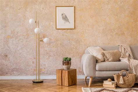 디자인 회색 소파 나무 커피 테이블 선반 큐브 카펫 등나무 푸프 식물 사진 프레임 테이블 램프와 가정 장식우아한 액세서리와 거실 인테리어에서 세련된 Scandi 퇴비 0명에