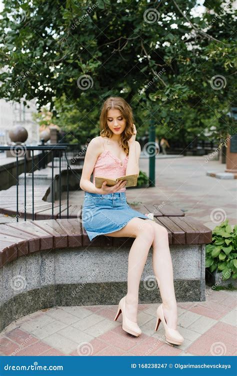 Ragazza In Abiti Estivi Con Gambe Lunghe Seduta Su Una Panchina All