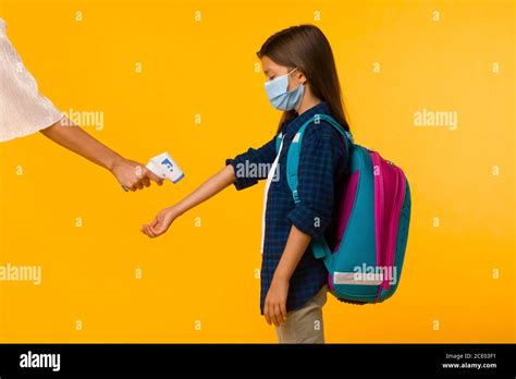 Teacher Measuring Temperature Of Girl With Thermometer Stock Photo Alamy
