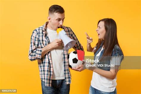 생상 재미 미친 커플 여자 남자 축구 팬 들 비명 손실의 화가 축구 공 레드 카드 노란 배경에 고립 된 확성기 좋아하는 팀의