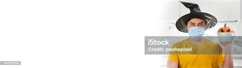 의료용 마스크를 착용하고 보호 마스크로 무서운 얼굴 호박을 들고있는 남자 축하 할로윈 긴 배너 10월에 대한 스톡 사진 및 기타 이미지 Istock