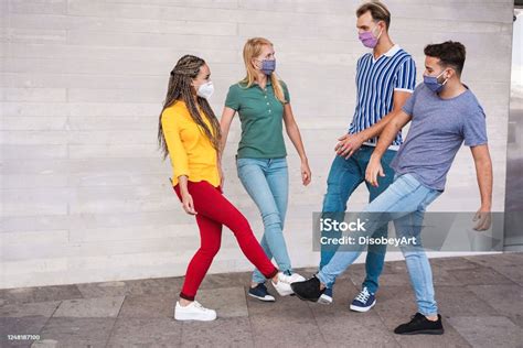 코로나 바이러스의 확산을 피하기 위해 인사하는 젊은 사람들 친구는 포옹이나 악수로 인사하는 대신 함께 발을 만지는 것을 만지며