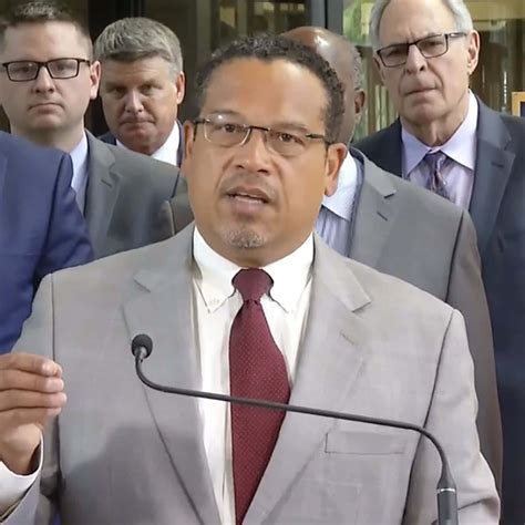 Download Keith Ellison With Men Behind Him Wallpaper