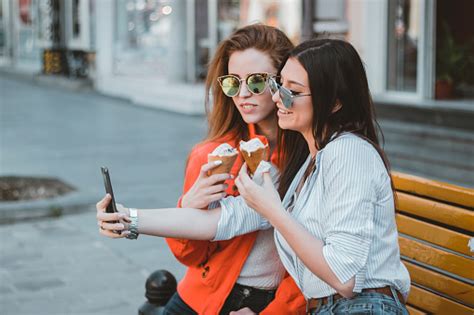 젊은 여자 친구는 시내 중심에 앉아서 차가운 아이스크림을 즐기고 셀 카를 복용 합니다 먹기에 대한 스톡 사진 및 기타 이미지 먹기 아이스크림 커플 Istock