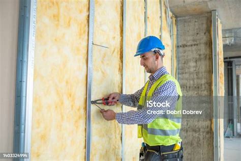젊은 쾌활한 건설 노동자는 건설 현장에서 노란 돌 양모로 일합니다 남자에 대한 스톡 사진 및 기타 이미지 남자 석고보드 40 44세 Istock