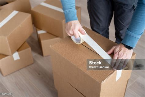 한 남자가 접착 테이프를 사용하여 골판지 상자를 포장합니다 이사 개념 이주 개념에 대한 스톡 사진 및 기타 이미지 이주 개념 상자 새 집으로 이사 Istock