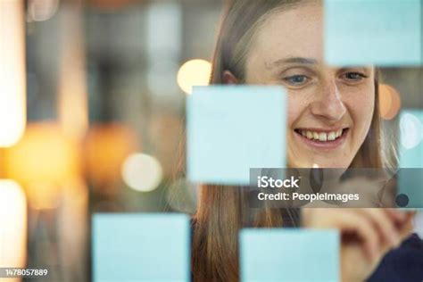 계획 전략 및 유리 벽 스티커 메모에 쓰는 여성 창의적인 스타트업 에이전시를 위한 브레인스토밍 아이디어 시장 조사 목표 및 목표