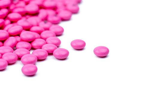 Closeup Pile Of Pink Round Sugar Coated Tablets Pills Isolated On White