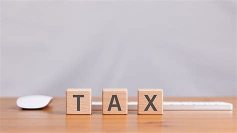 흰색 배경에 컴퓨터 마우스와 키보드가 있는 나무 테이블에 세금 텍스트가 있는 나무 큐브 블록 개념에 대한 스톡 사진 및 기타