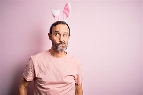 입술 미친 코믹 한 제스처와 물고기 얼굴을 만드는 고립 된 분홍색 배경 위에 서 토끼 귀를 입고 중년 Hoary 남자 재미있는 표현 의상에 대한 스톡 사진 및 기타 이미지