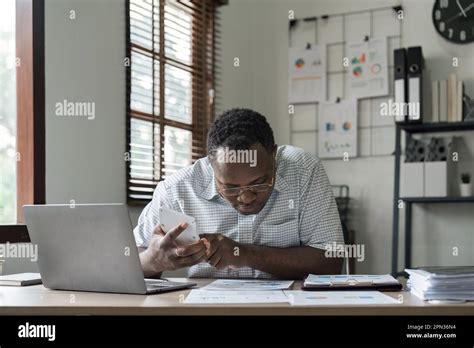 African American Man Calculating Using Machine Managing Household Finances At Home Focused