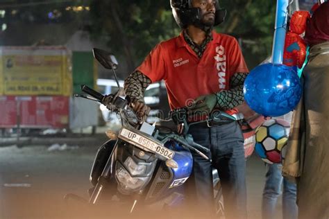 Zomato Rider On Bike Waiting To Pick Up Order On Street Side In Iconic