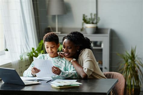 어머니와 함께 집에서 공부하는 동안 시험 결과를 들고 웃고 있는 십대 소녀의 정면 초상화 사진 Unsplash의 사람 이미지