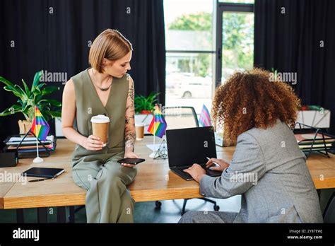 Two Colleagues Engage In A Discussion While Embracing A Colorful