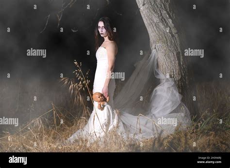 Horror Scene Of A Woman Possessed Holding A Doll Stock Photo Alamy
