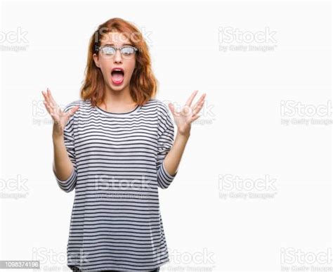 아름 다운 젊은 여자 이상 미친을 축 하 하는 안경을 쓰고 배경 절연 하 고 무기와 성공을 위한 흥분 비명 제기 및 오픈 눈 깜짝 놀라게 우승자 개념 긍정적인 감정 표현에