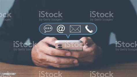 남자는 스마트 폰 문의 또는 이메일 마케팅 개념 고객 지원 핫라인 연락처 사람들 연결을 사용합니다 이메일 전화 전화 주소 채팅 메시지 아이콘이 있는 큐브 나무 키보드