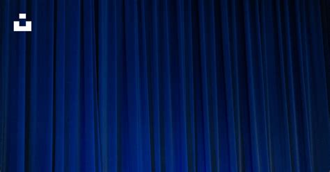 양복과 넥타이를 입은 남자가 파란 커튼 앞에 서 있다 사진 Unsplash의 무료 파랑 이미지