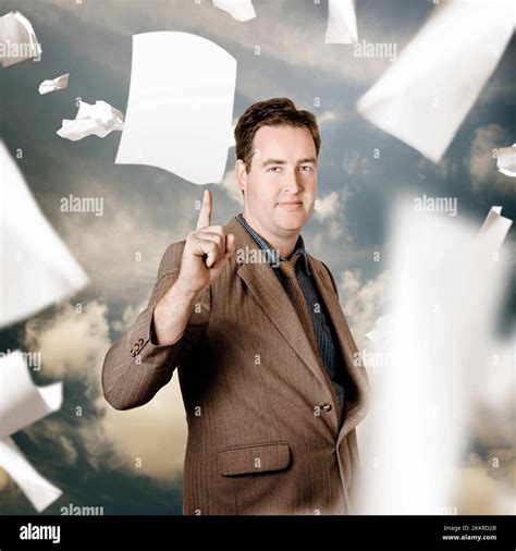 Businessman Standing Outdoors Pointing Up To Blank Sign Paper Floating In The Wind Marketing