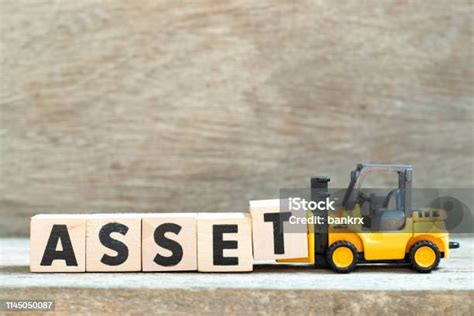 나무 배경에서 워드 자산을 완료 하는 장난감 지게차 홀드 편지 블록 T 개념에 대한 스톡 사진 및 기타 이미지 개념 경제 금융 Istock