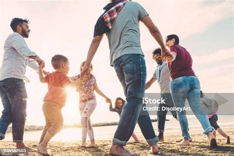 가족 친구 들이 석양 해변에서 즐거운 시간을 보내세요아버지 어머니 어린이와 삼촌이 함께 연주사랑 관계 파티 및 축 하 개념클로즈업 남자 몸에 대 한 주요 초점 가족에 대한