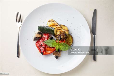 테이블에 나이프와 포크가 있는 흰색 접시에 구운 야채의 상위 뷰 0명에 대한 스톡 사진 및 기타 이미지 0명 가지 채소