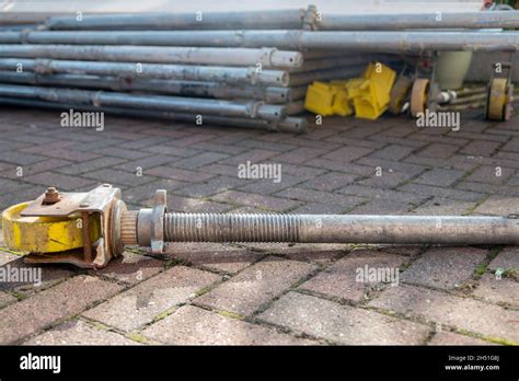 Pile Of Components Of Hired Scaffolding Or Mobile Platform Work Tower Including Adjustable Leg