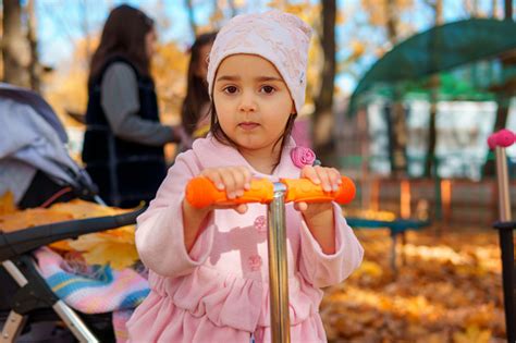 한 소녀가 가을 도시 공원의 길을 따라 스쿠터를 타고 행복한 아이는 아름다운 자연 밝고 화창한 날과 노란 나뭇잎을 즐깁니다 10월에 대한 스톡 사진 및 기타 이미지 Istock