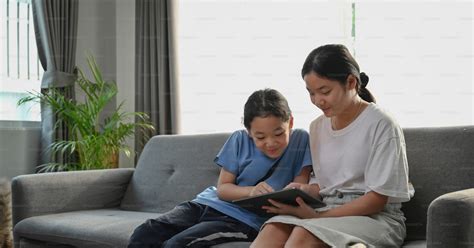 집에서 소파에 앉아 디지털 태블릿을 함께 사용하는 두 명의 행복한 소녀 사진 Unsplash의 앉아 이미지