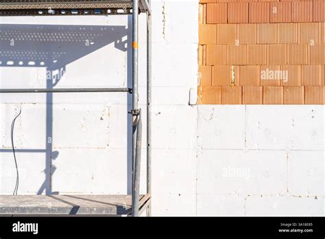 Scaffolding Stands Before Insulated Wall During Building Construction