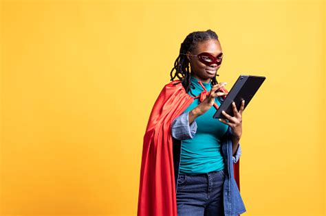 유쾌한 여자가 노트북 스튜디오 배경에서 작업하는 의상을 입고 영웅으로 포즈를 취하고 있습니다 가공의 인물에 대한 스톡 사진 및 기타 이미지 Istock