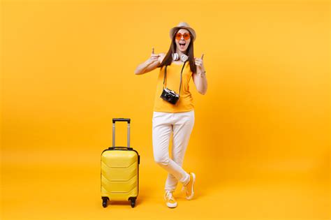 여행자 관광 여자 여름 캐주얼 옷에 노란색 오렌지 배경에 고립 목에 헤드폰으로 모자 주말도 주에 여행을 해외 여행 하는 승객 공기 비행 여행 개념입니다 Unmanned