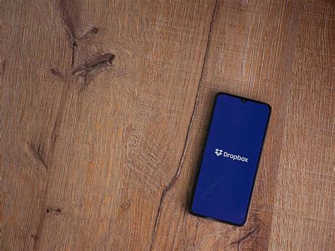 Black Mobile Displaying Dropbox App Launch Screen With Prominent Logo
