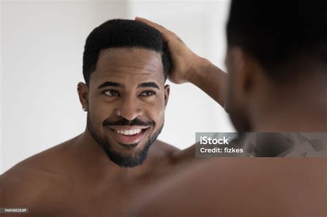 거울을 바라보는 아프리카 남자가 그의 자연스러운 아프로 머리를 만진다 남자에 대한 스톡 사진 및 기타 이미지 남자 털
