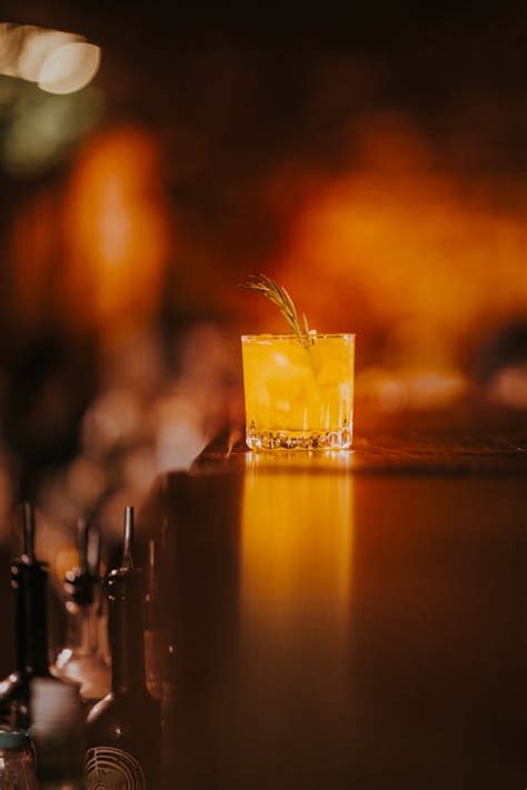 희미한 조명의 바 카운터에서 우아한 칵테일 · 무료 스톡 사진
