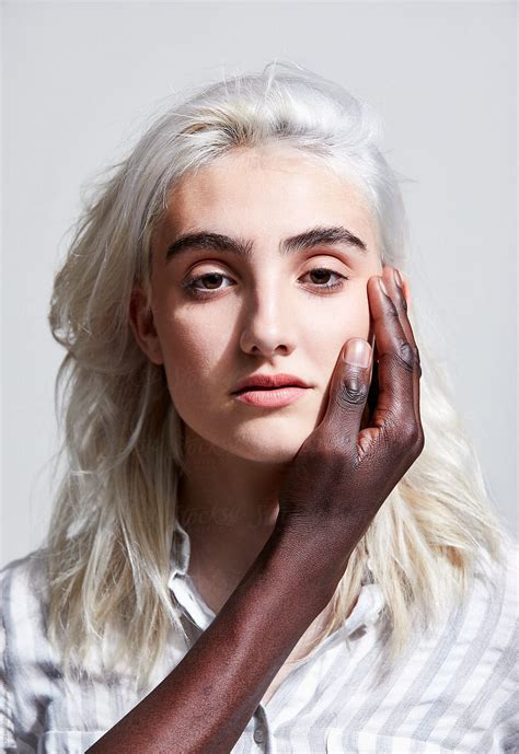 A Portrait Of A Young Woman With Mans Hand On Her Face By Stocksy