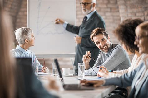 행복 한 사업가 사무실에서 프레 젠 테이 션에 그의 동료에 게 얘기 Staff Meeting에 대한 스톡 사진 및 기타 이미지 Staff Meeting 그래픽 디자이너
