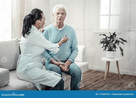 Old Embarrassing Man Sitting And Having Medical Examination Stock