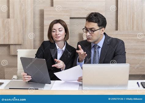 Two Concentrated Office Workers Working At The Desk On Laptop In The