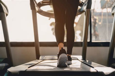 피트니스 운동 체육관 운동 라이프 스타일과 건강한 개념 체육관에서 러닝머신을 걷는 여성의 다리와 발을 클로즈업하여 일몰 시 건강과 근력을 유지합니다 러닝머신에 대한 스톡